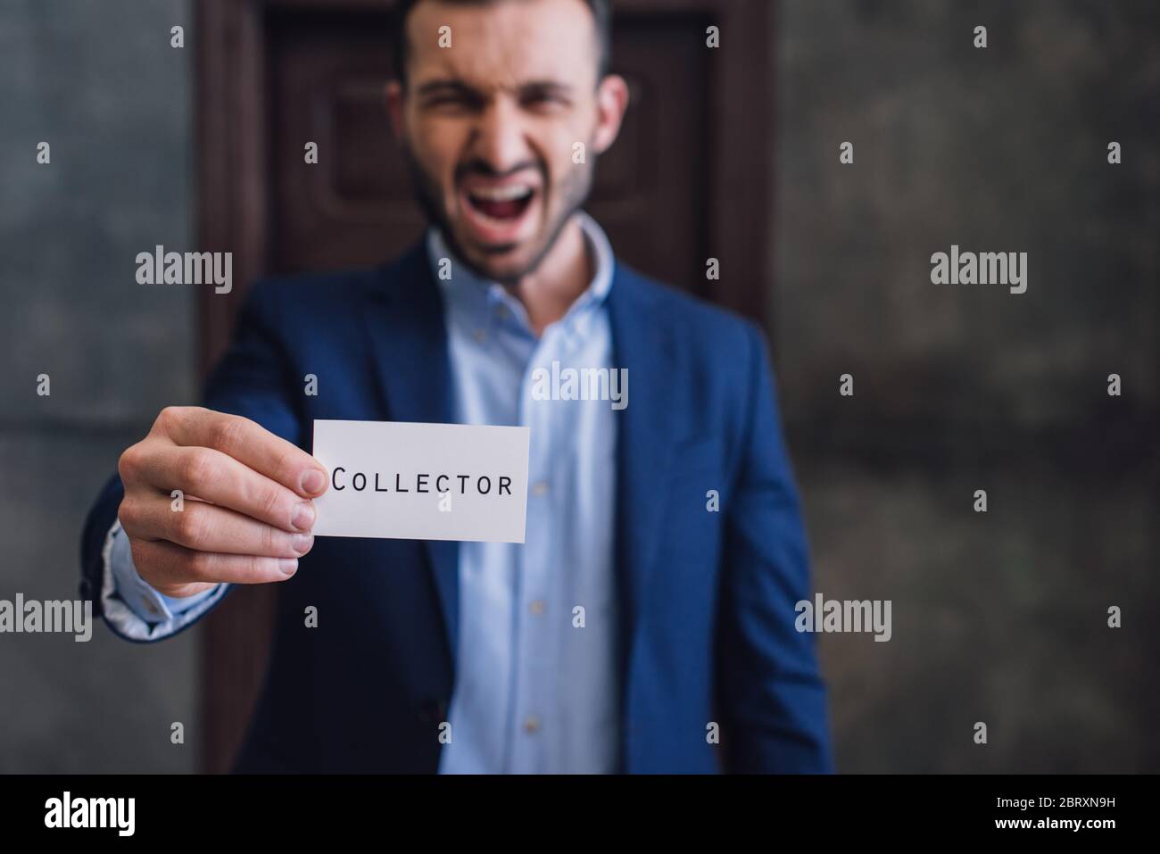 Selective focus of angry collector shouting and showing card with ...