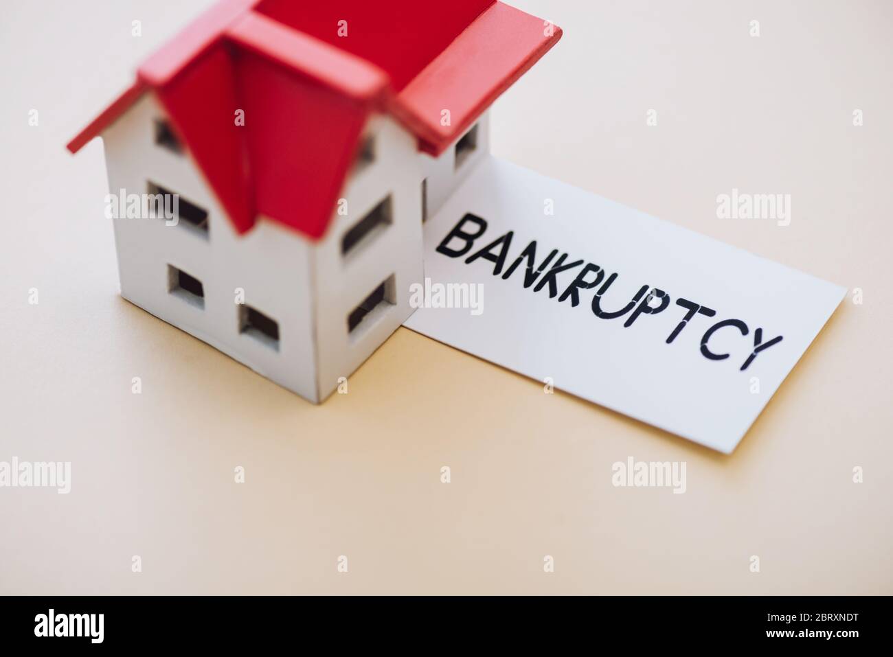 High angle view of card with bankruptcy lettering and house model on ...