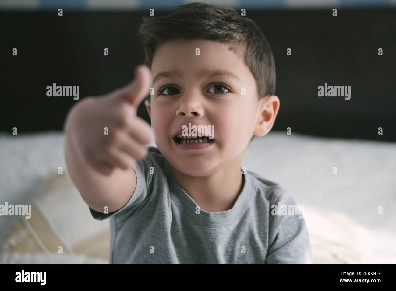 selective focus of cute toddler boy pointing with finger and looking at ...