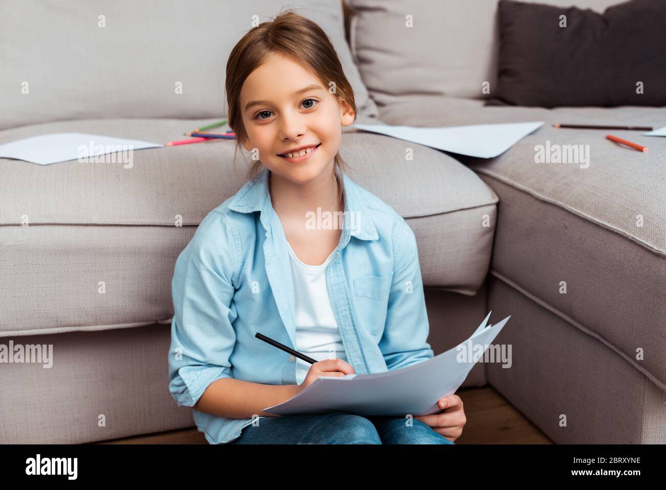 cute child smiling while drawing in living room Stock Photo - Alamy