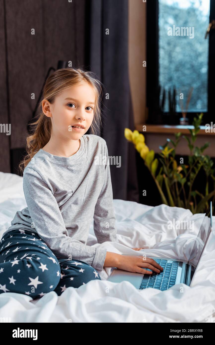 cute kid using laptop with e-learning in bedroom Stock Photo - Alamy