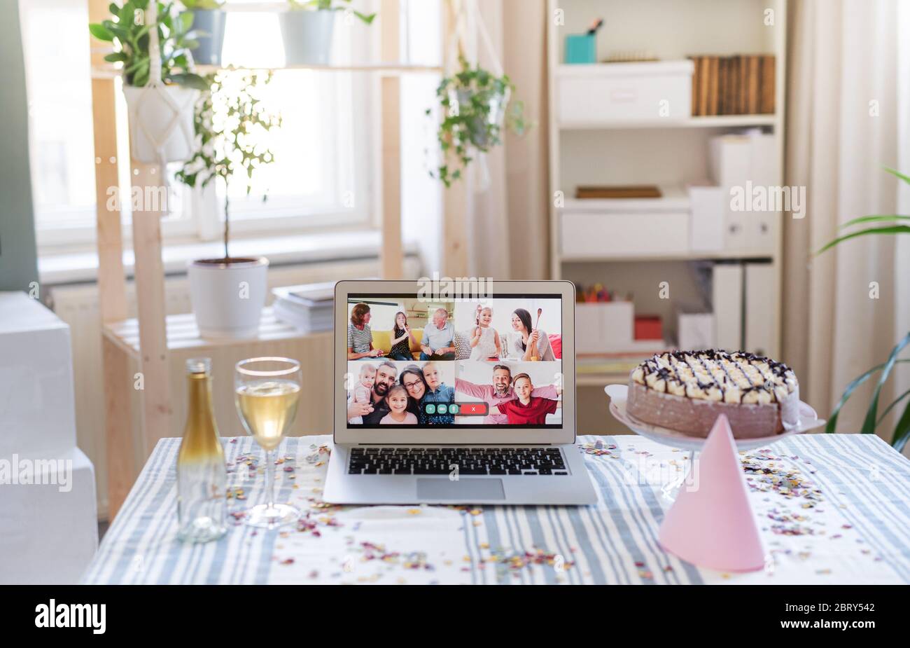 Laptop on table indoors, family chat and distance birthday celebration ...