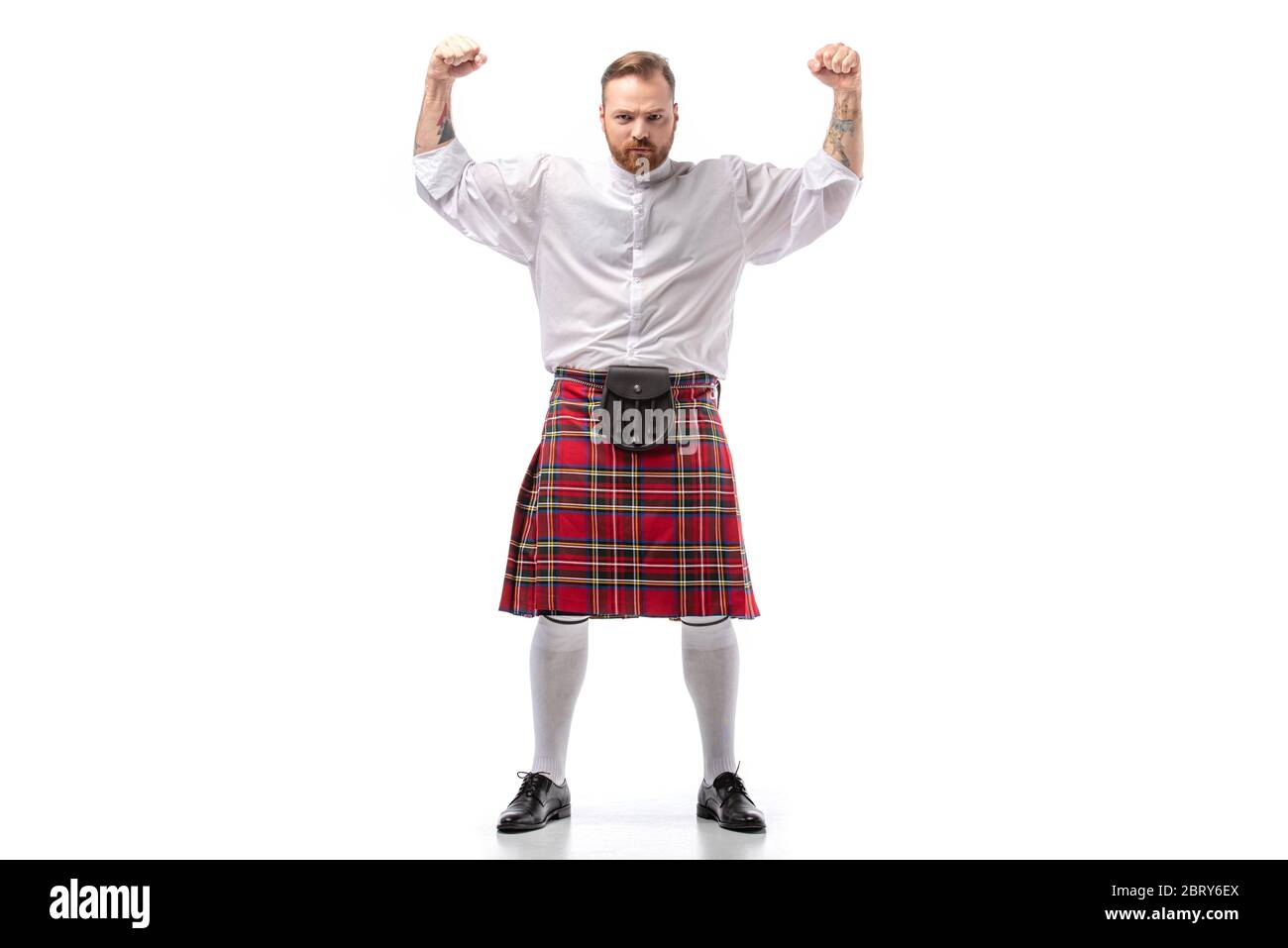 strong Scottish redhead man in red kilt showing fists on white ...