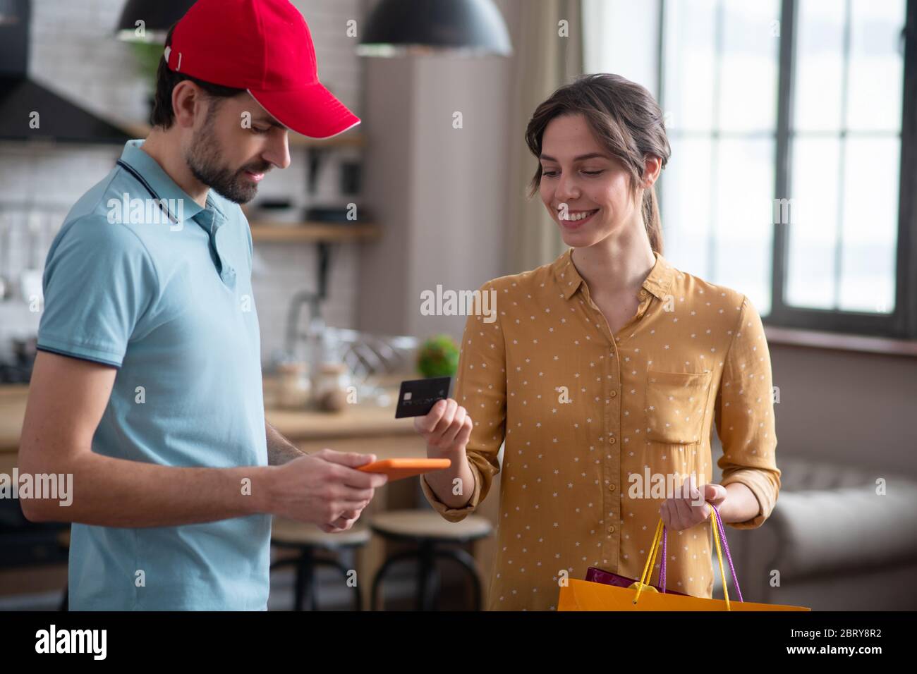 Female customer giving a credit card to delivery person for payment and ...