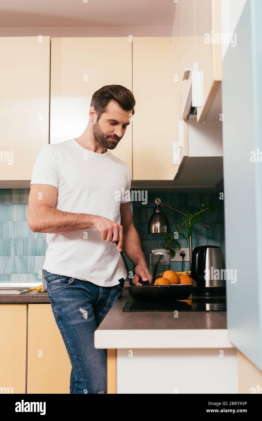 Selective focus of handsome man cooking breakfast in kitchen Stock ...