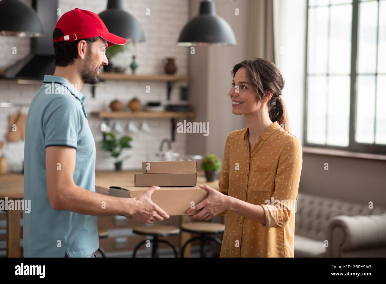 Female customer receiving delivery and smiling positively Stock Photo ...