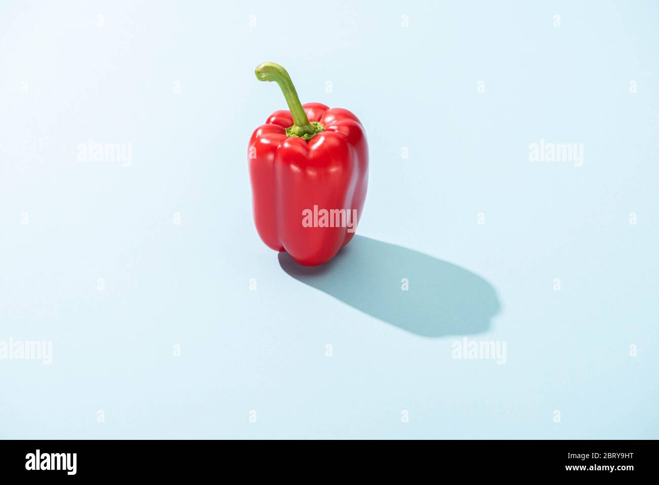 fresh red bell pepper on blue surface with shadow Stock Photo - Alamy