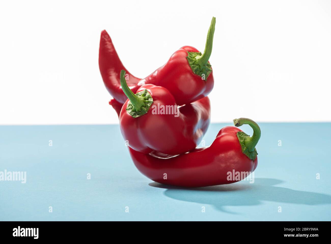 fresh red chili peppers on blue surface isolated on white Stock Photo ...