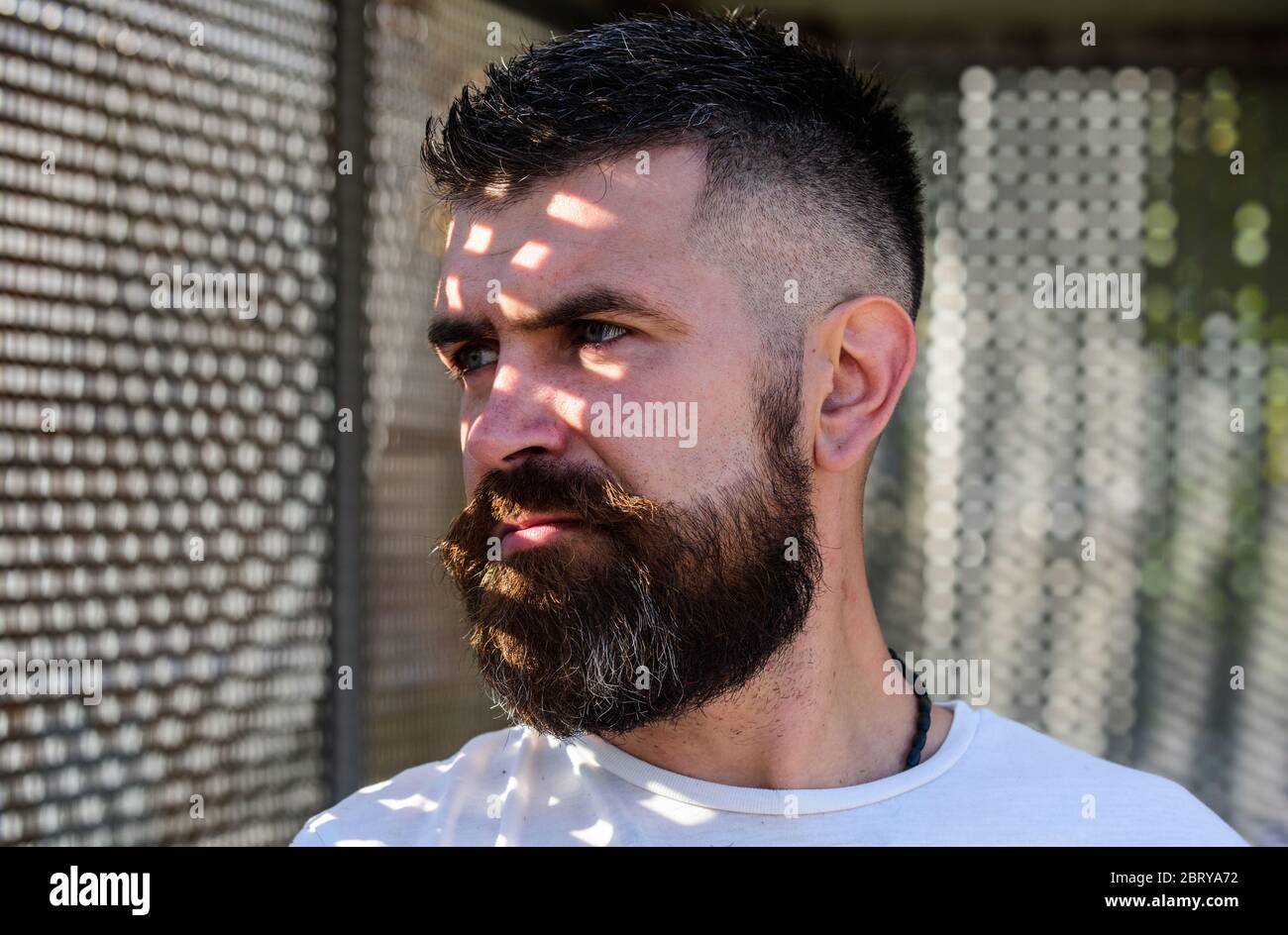 Man with serious face and dots of light and shadow on his face, close ...