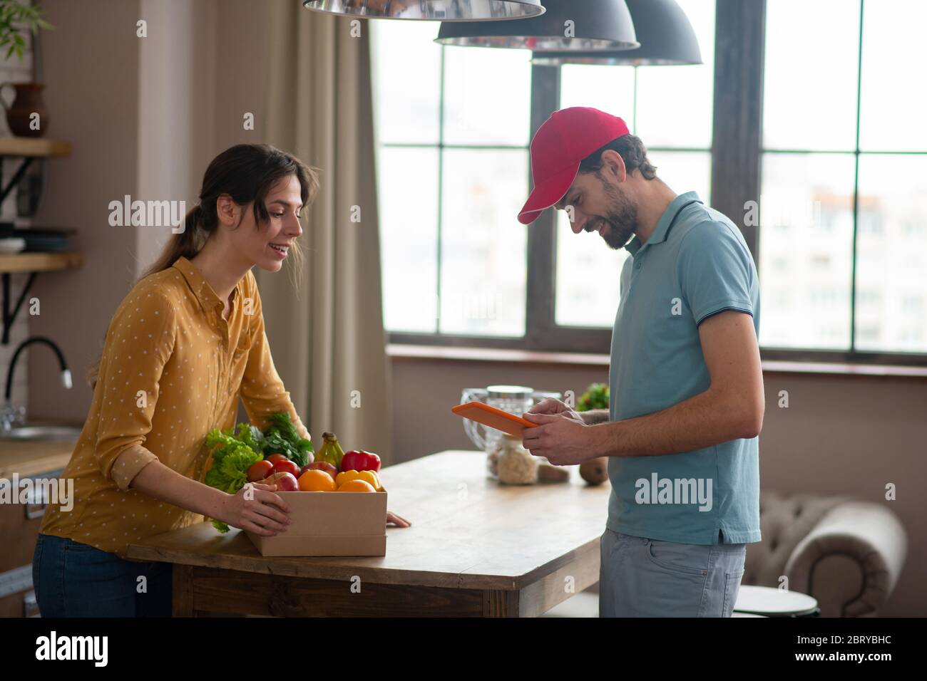 Woman receiving home food delivery from a courrier Stock Photo - Alamy