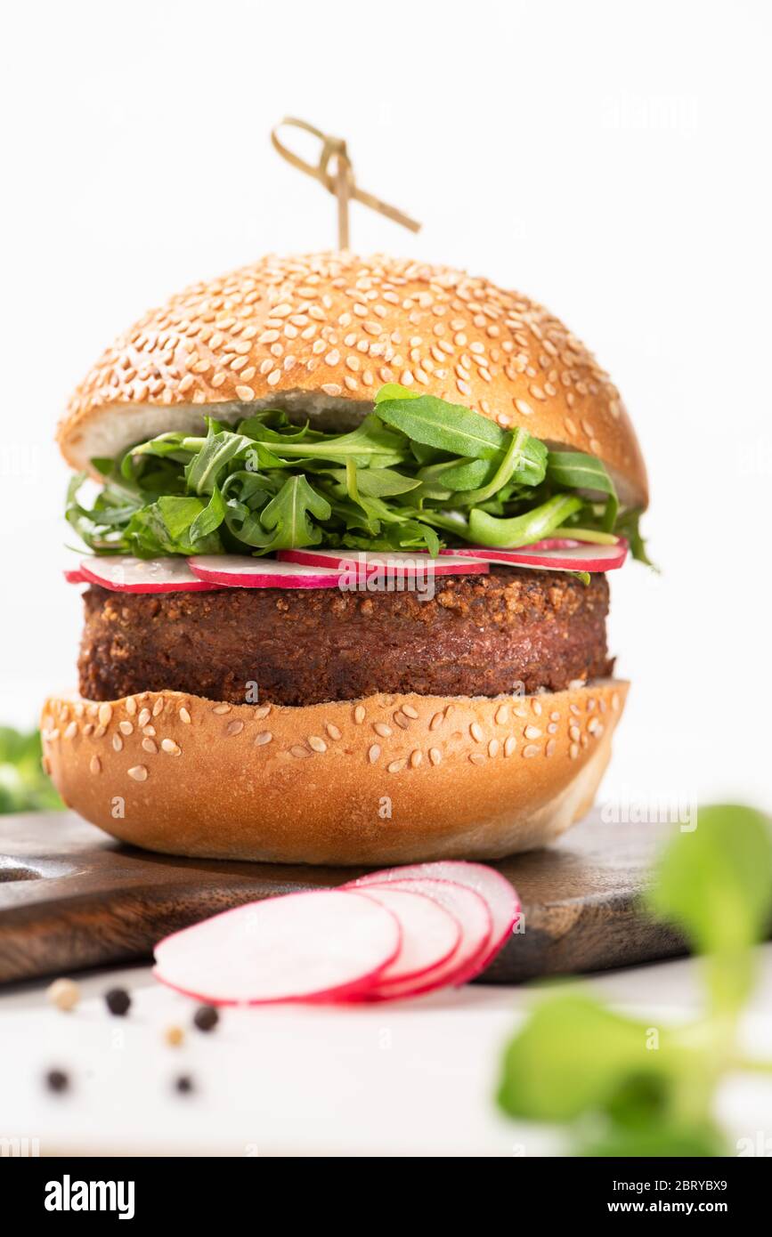 selective focus of delicious vegan burger with radish and arugula on ...
