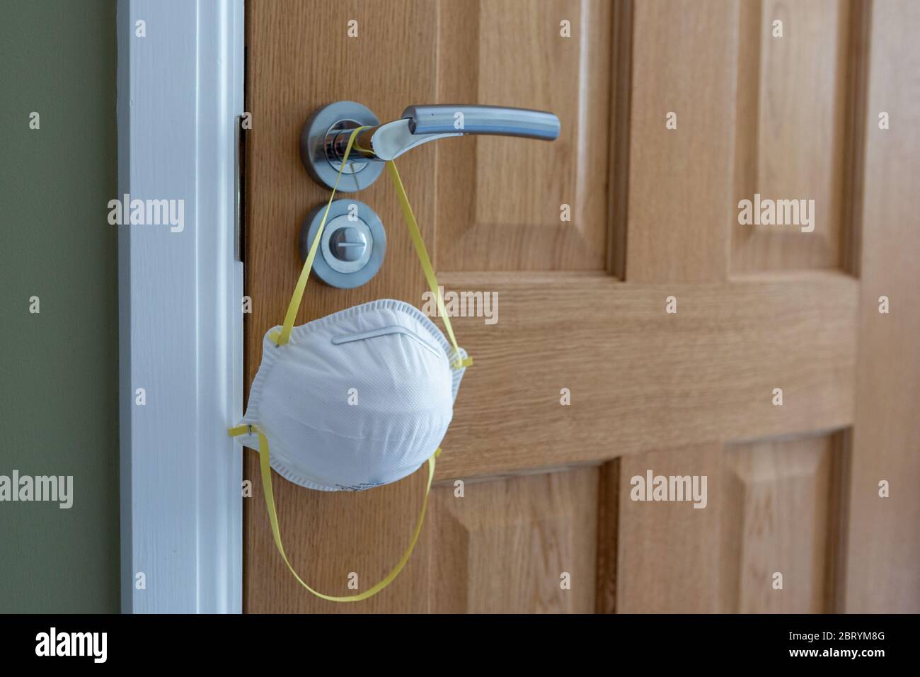 Face mask hanging on a door handle representing the 2020 coronavirus ...