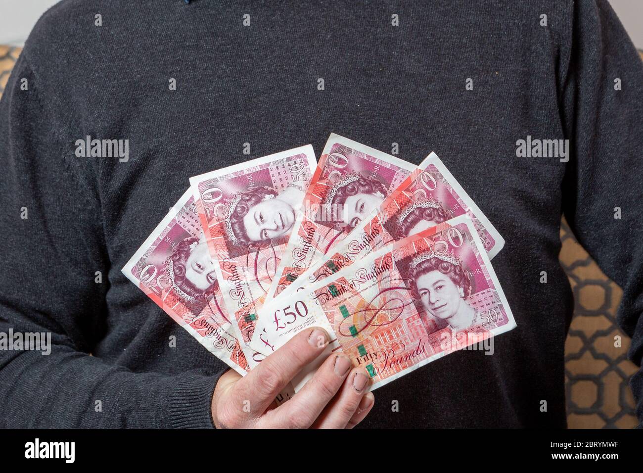 Man holding a load of money, pound notes in is hands Stock Photo - Alamy