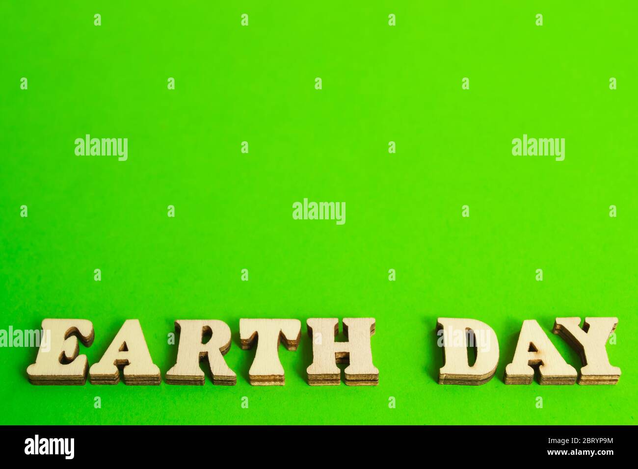 Earth Day. Words made from simple wooden letters on a green background ...