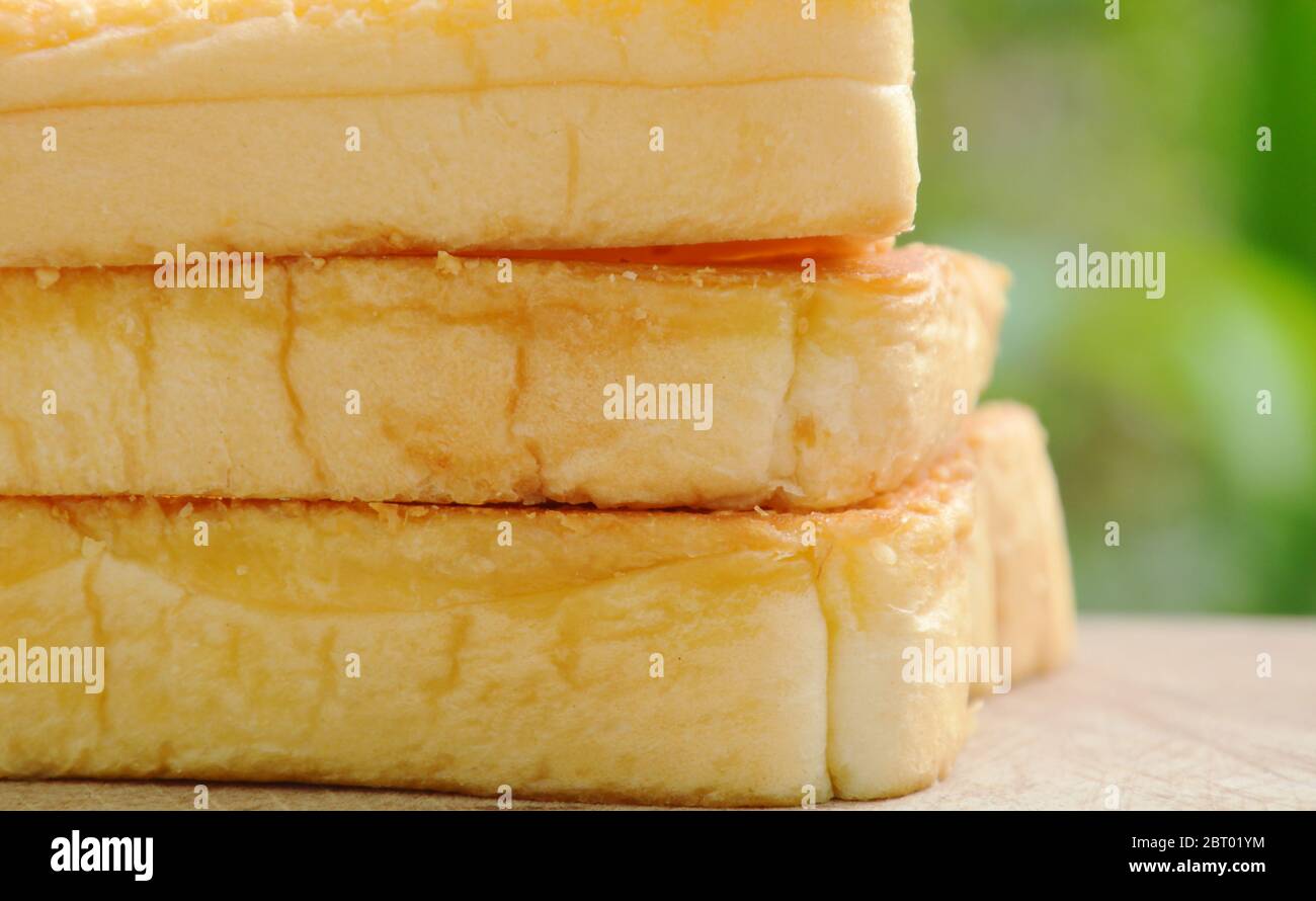 baked cheese bread slice on wooden chopblock Stock Photo - Alamy