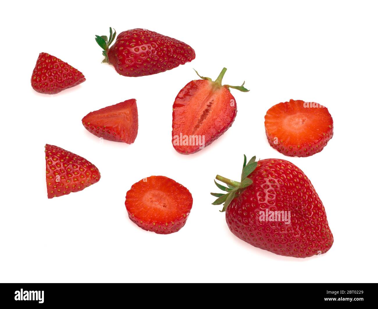 Isolated strawberries. One whole fruit and cut berries on white ...