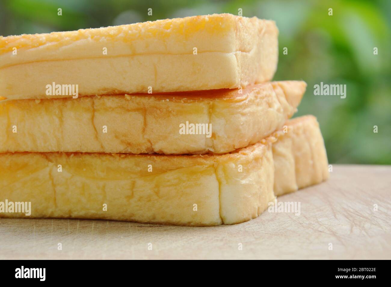 baked cheese bread slice on wooden chopblock Stock Photo - Alamy