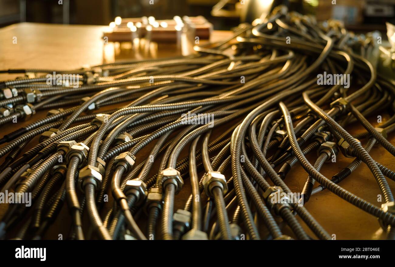 Close-up of a huge bunch of metal flexible tubes with nuts ...