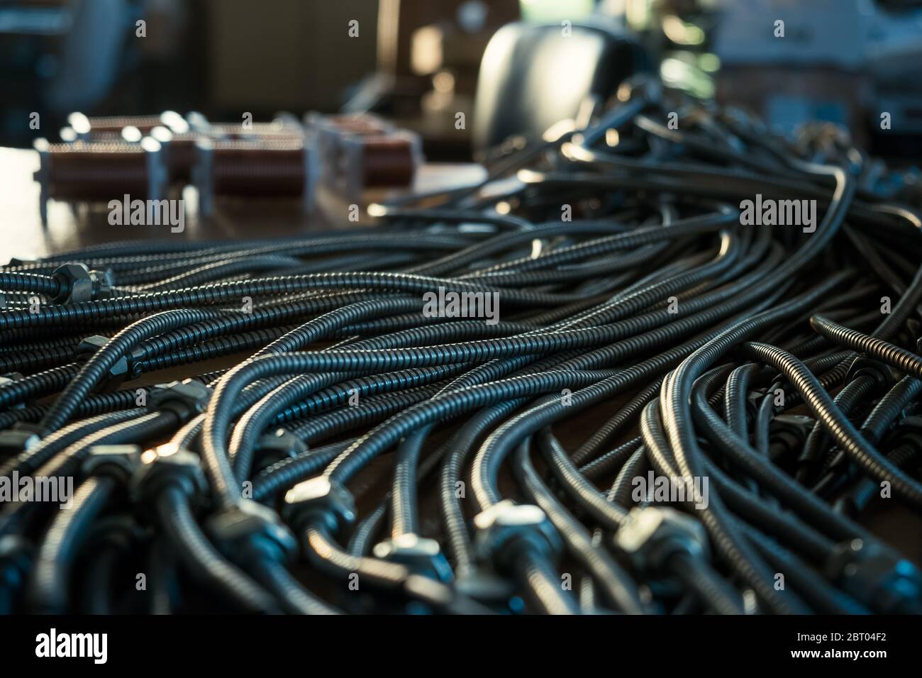 Close-up of a huge bunch of metal flexible tubes with nuts ...