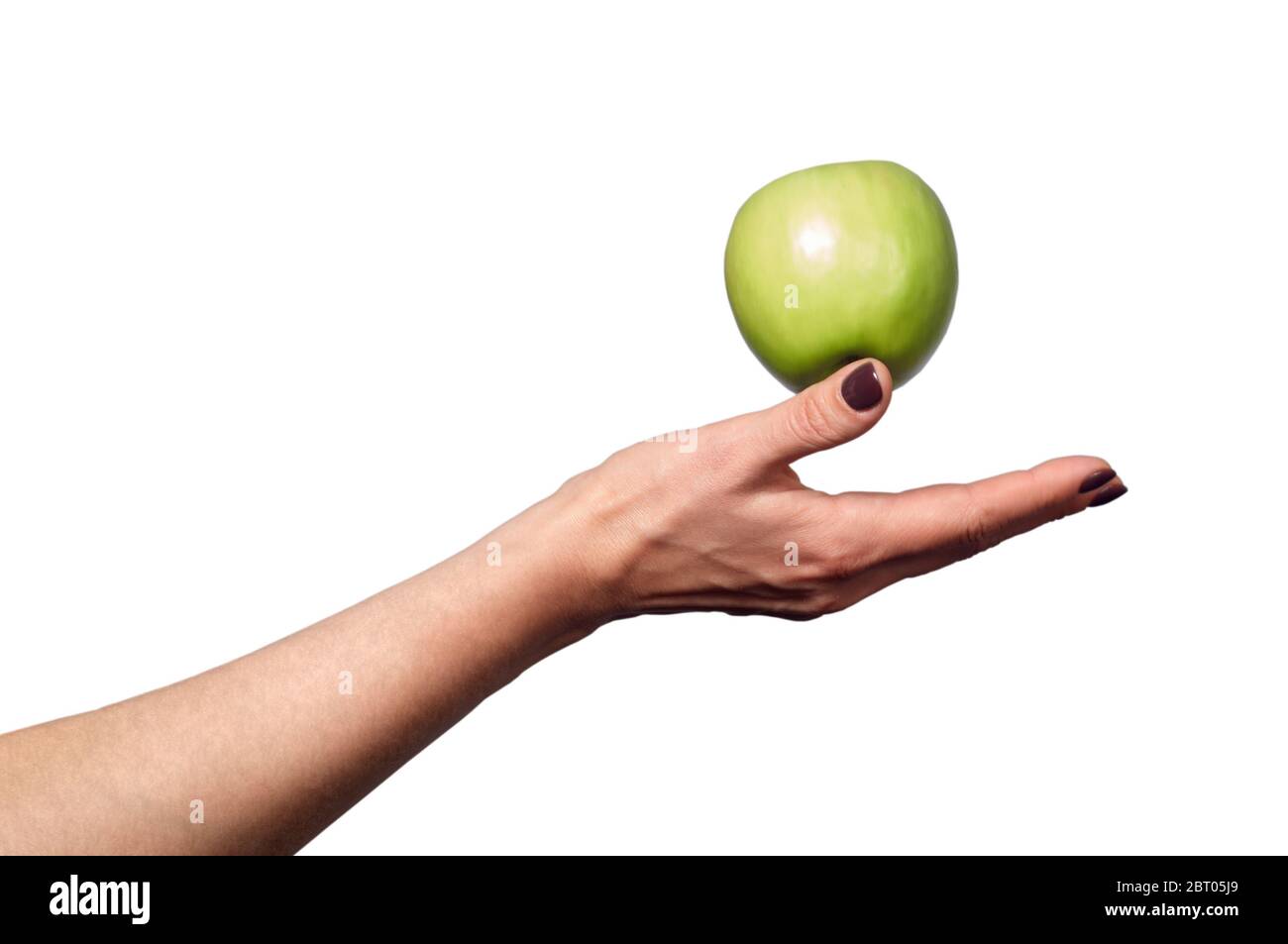Hand tossing green apple in the air Stock Photo - Alamy