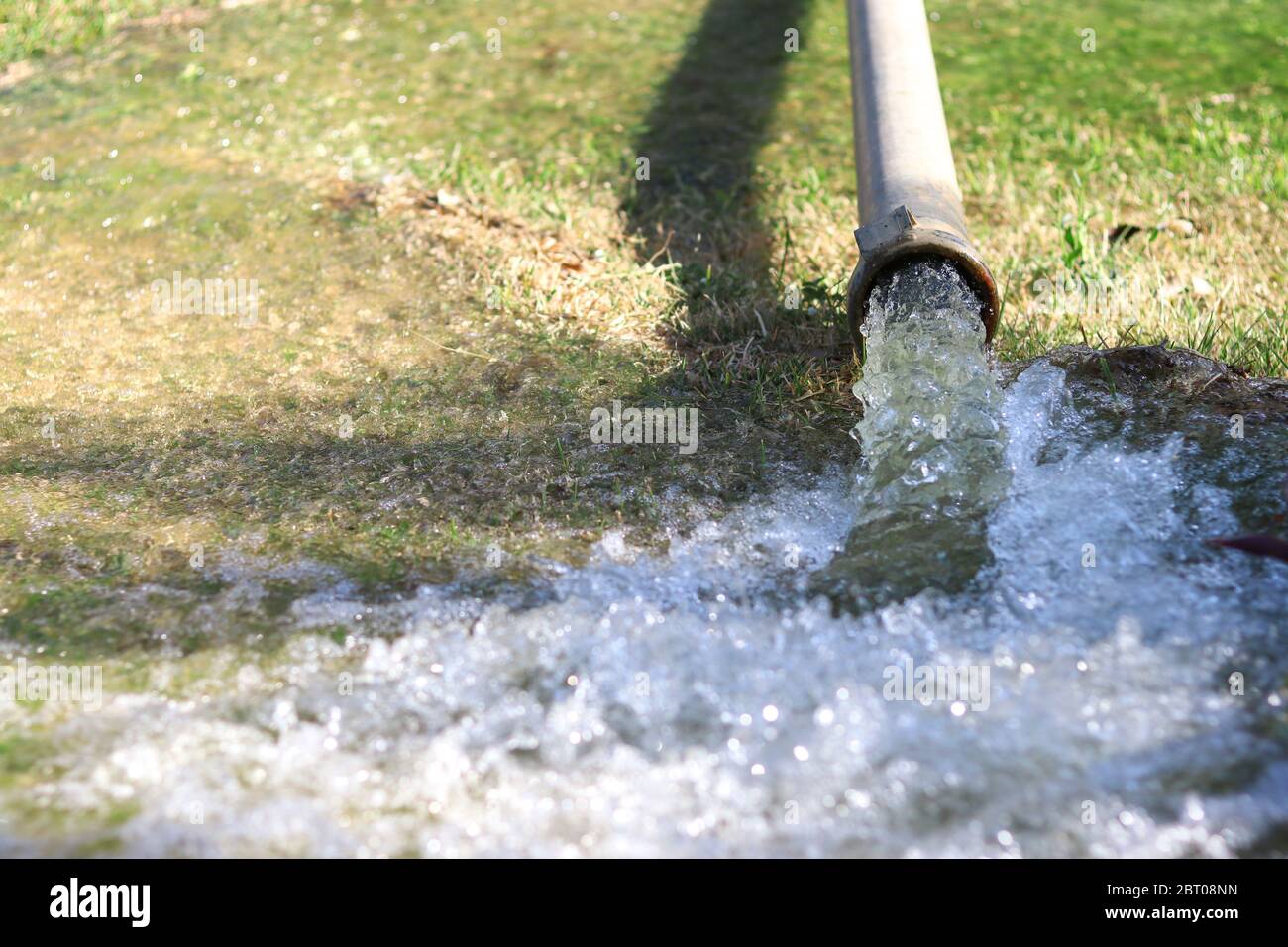 The water was gushing out from a metal pipe on the lawn Stock Photo - Alamy