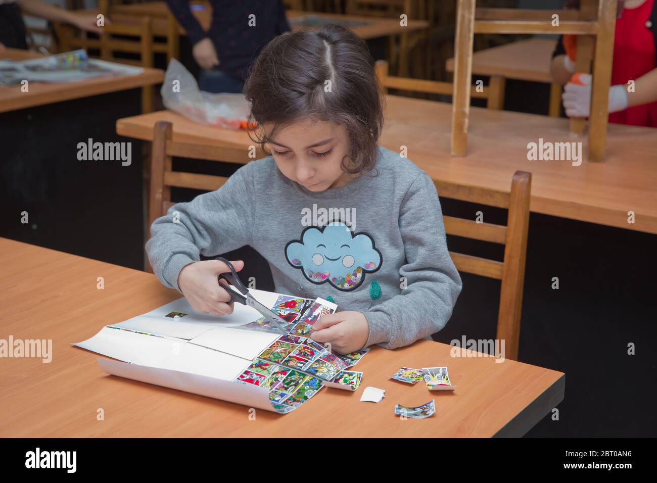 Portrait of a little girl cutting a paper . Little preschooler girl ...