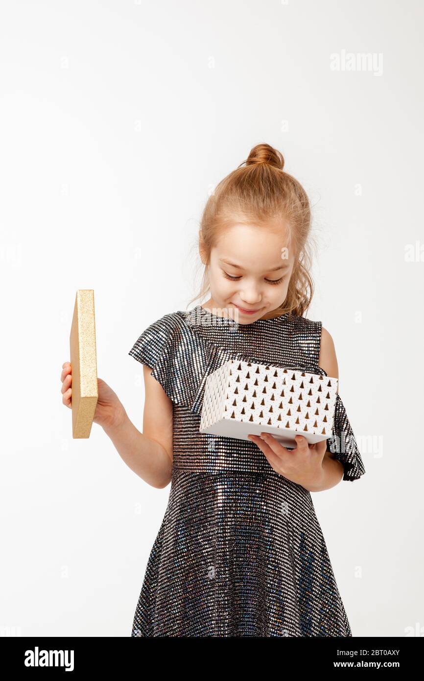 girl in a party dress that opens a box with a gift Stock Photo - Alamy