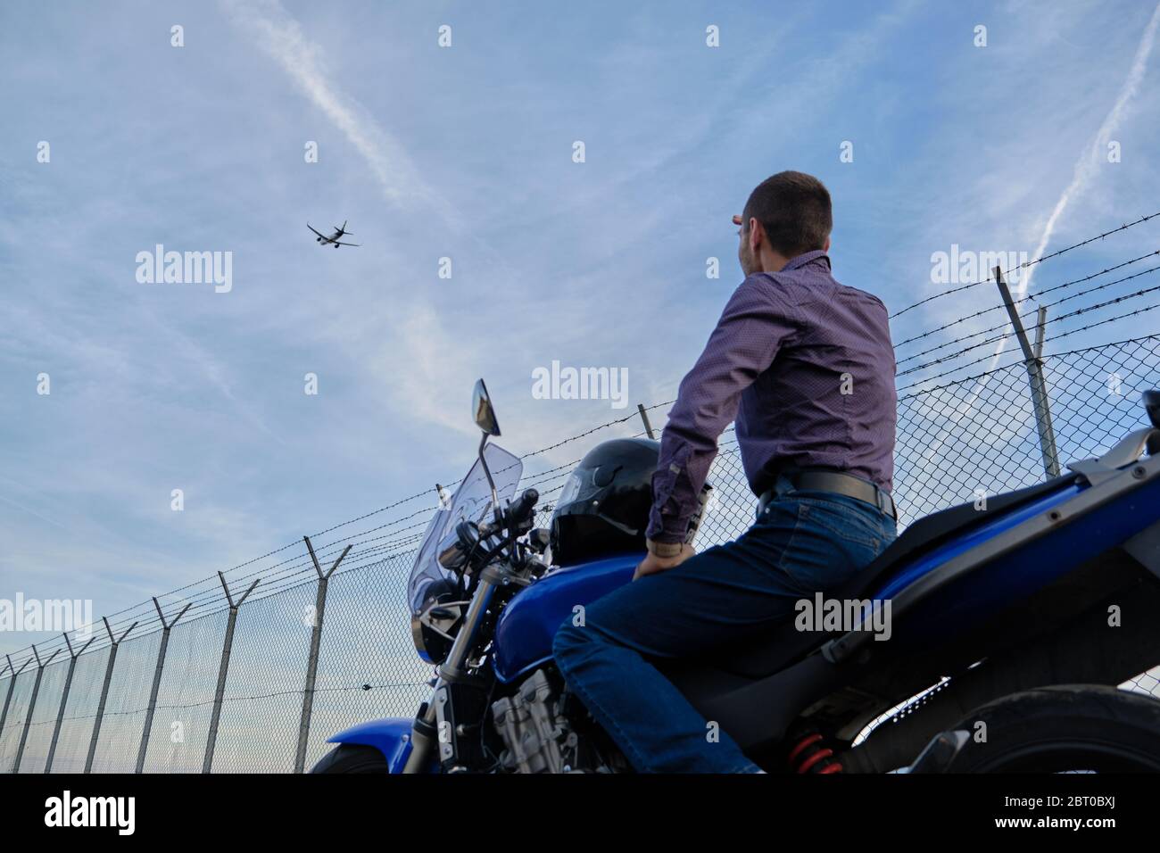 Unrecognazible Man Sitting On Motorcycle Looking Plane In The Air ...
