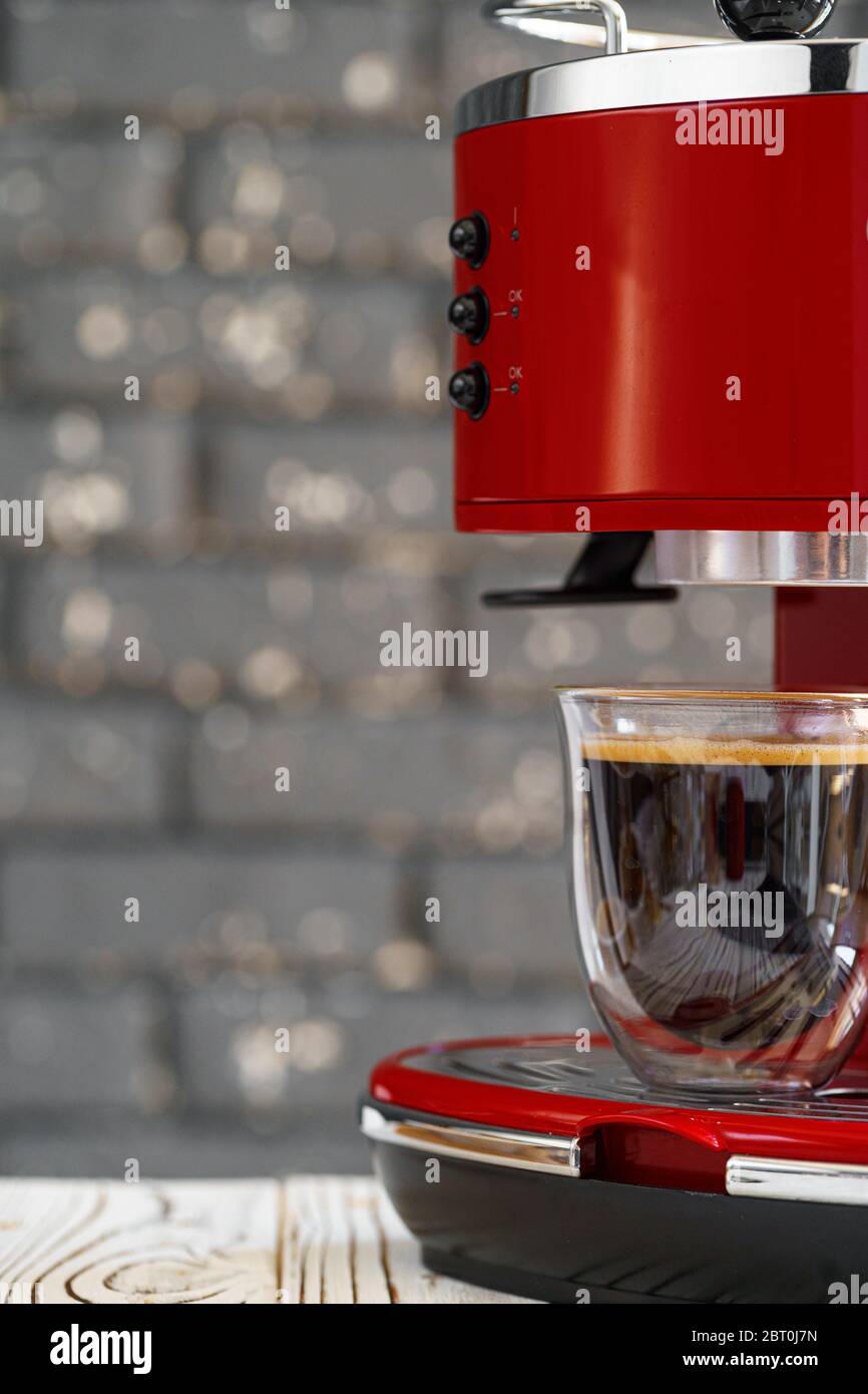 Red coffee machine with a glass on kitchen counter Stock Photo - Alamy
