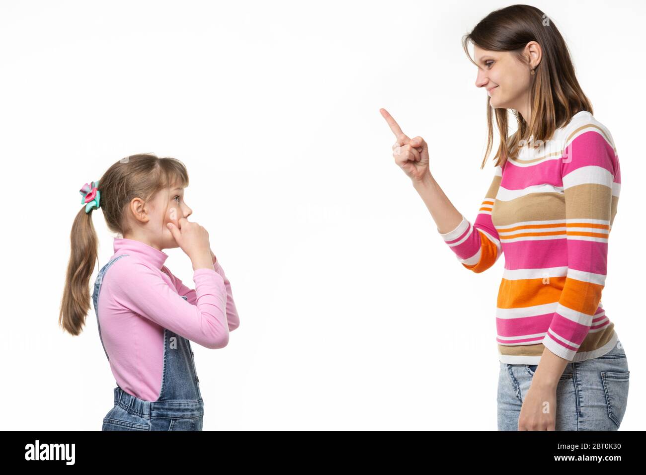 Mom shows the index finger to the girl, daughter looks at mom in fear ...