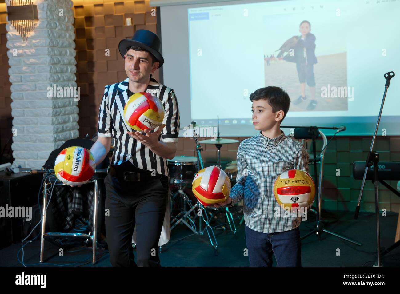 Man juggling blue balls . Stylish Man and boy with black and white ...