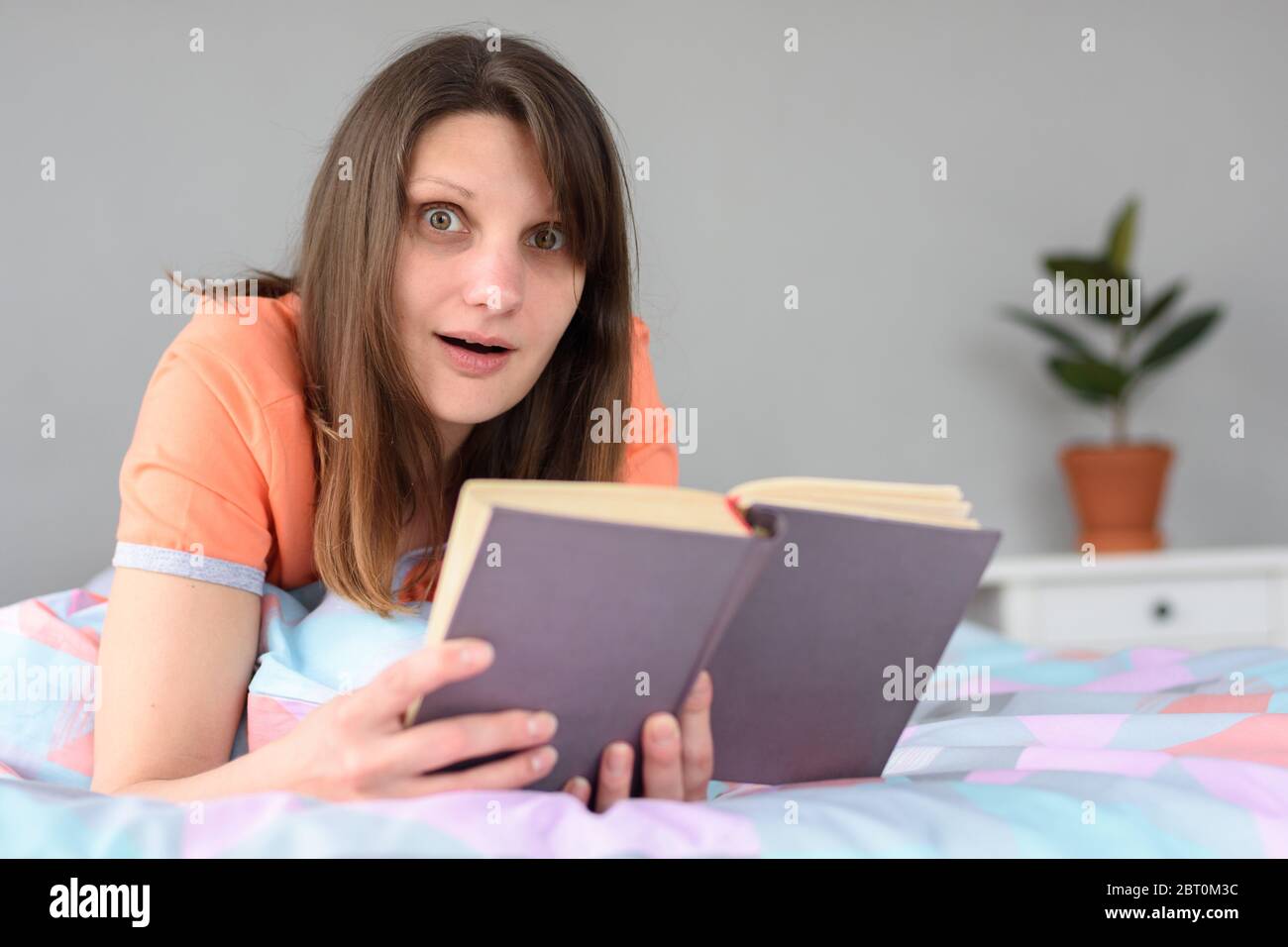 The girl in a slight shock from reading in a book Stock Photo - Alamy