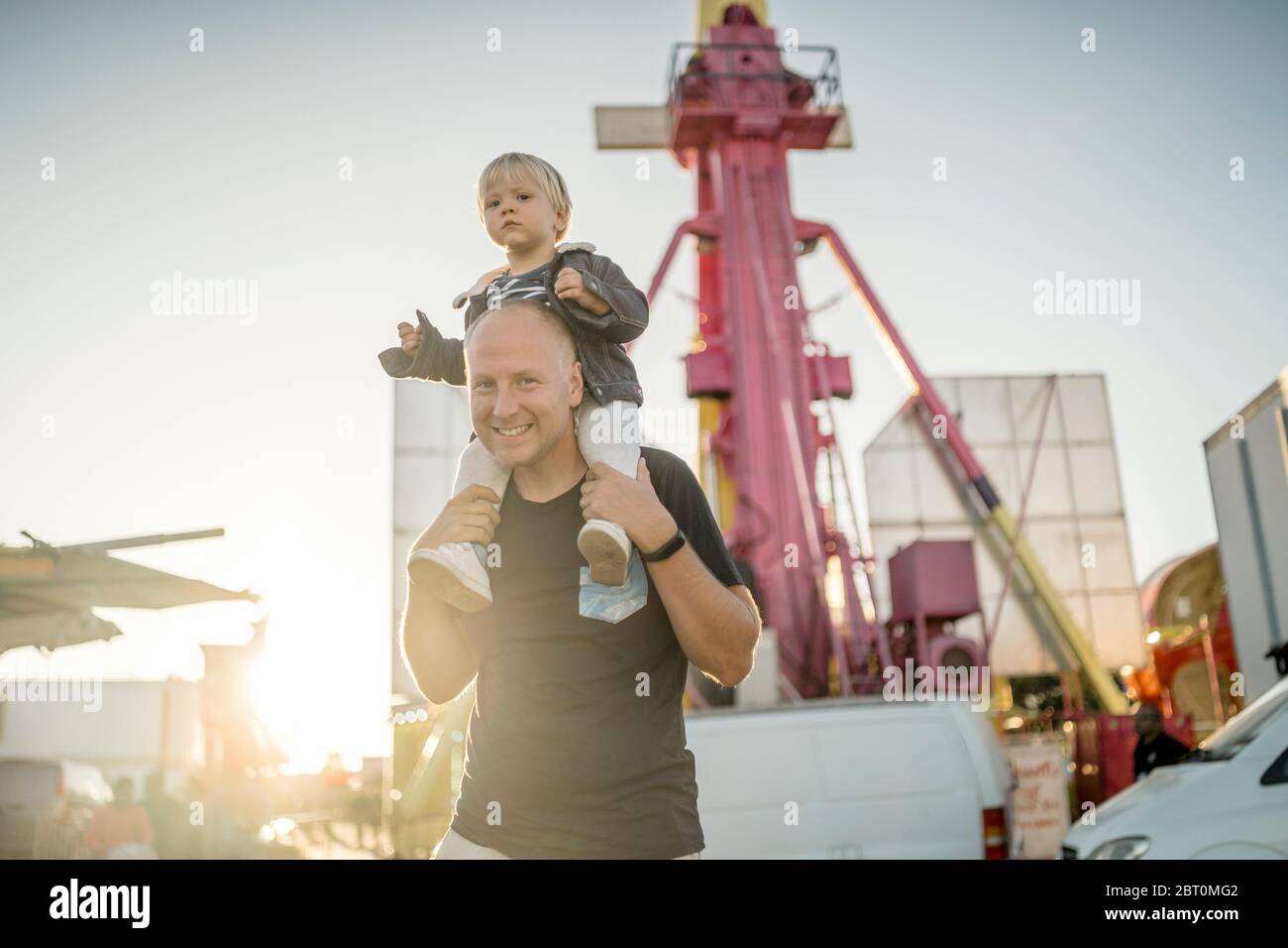 Happy father with his little piggybacked son in an amusement park Stock ...