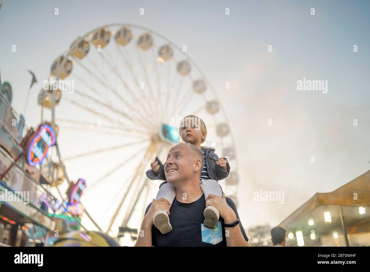 Happy father with his little piggybacked son in an amusement park Stock ...