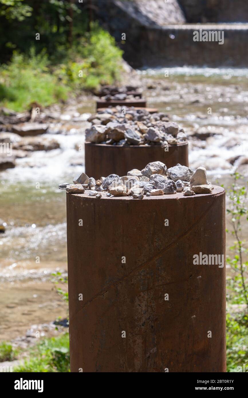 Iron columns filled with stones as a driftwood barrier in the ...