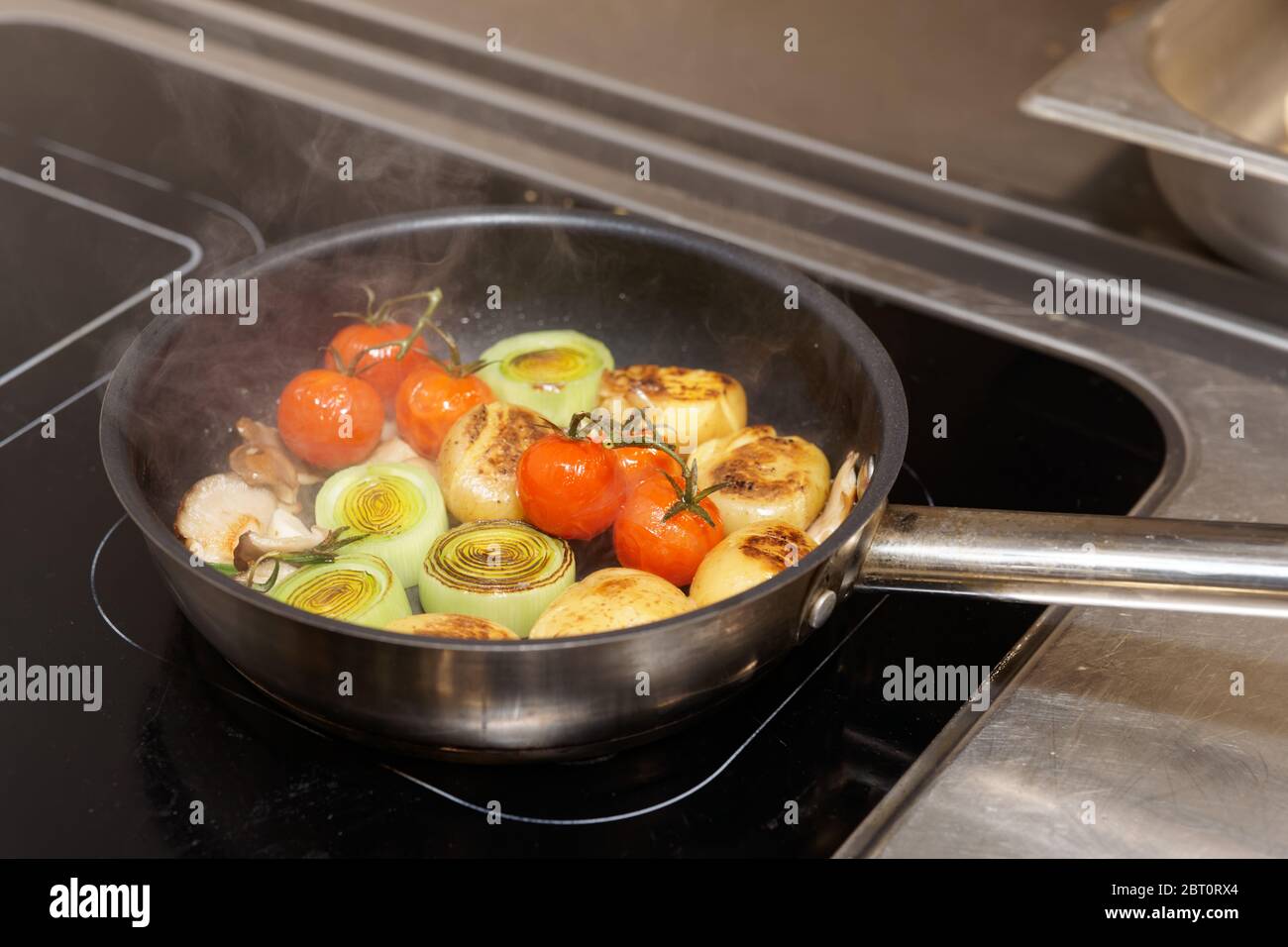 Frying vegetables in pan, commercial kitchen Stock Photo - Alamy