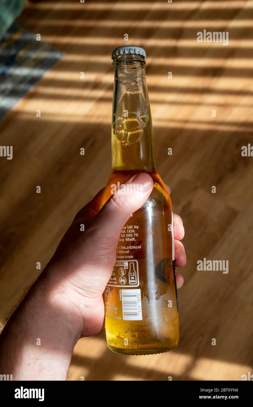 A man holding beer indoors on a warm sunny day during lockdown Stock ...