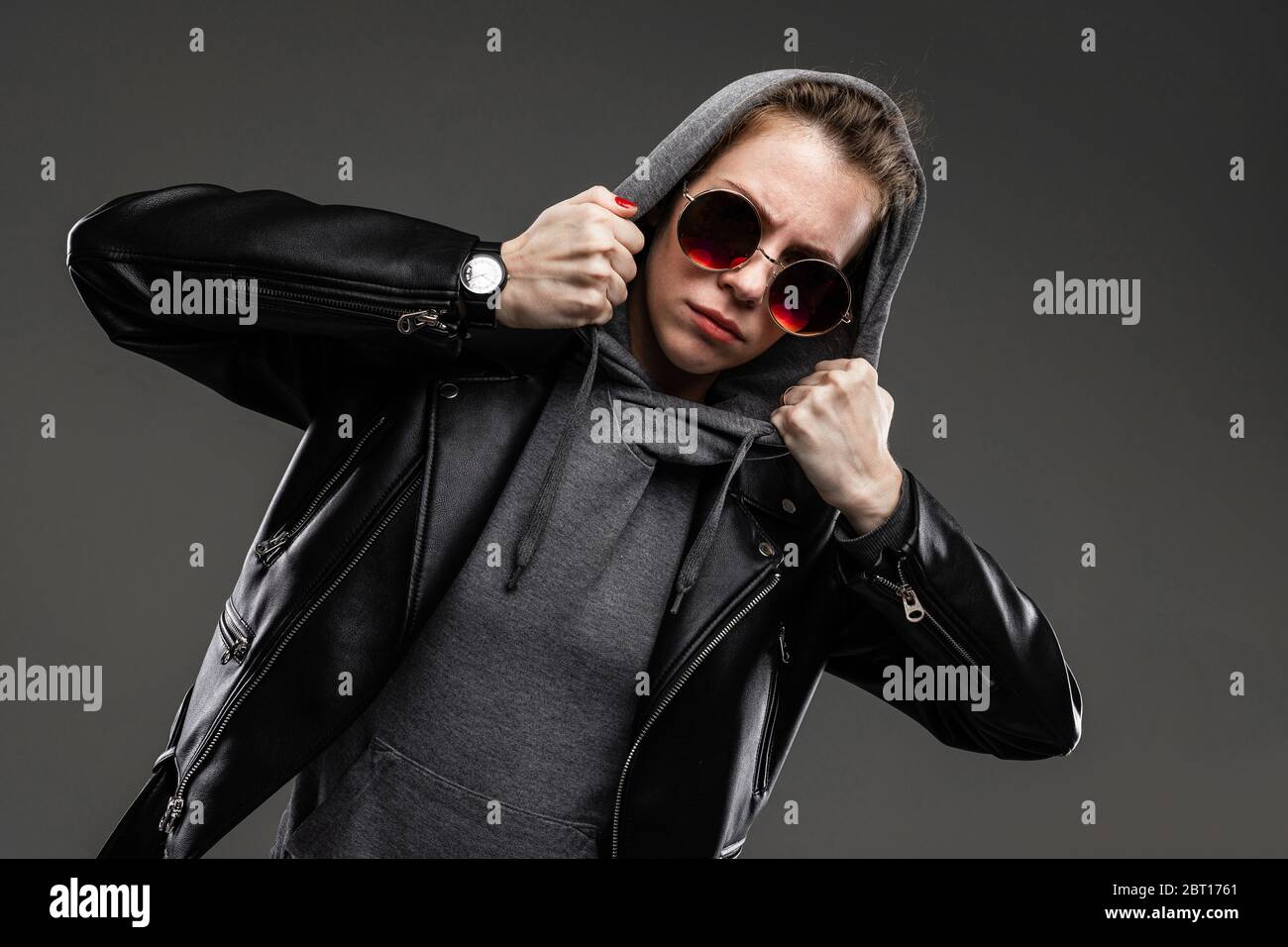 Brutal caucasian girl with rough facial features in a black jacket with ...