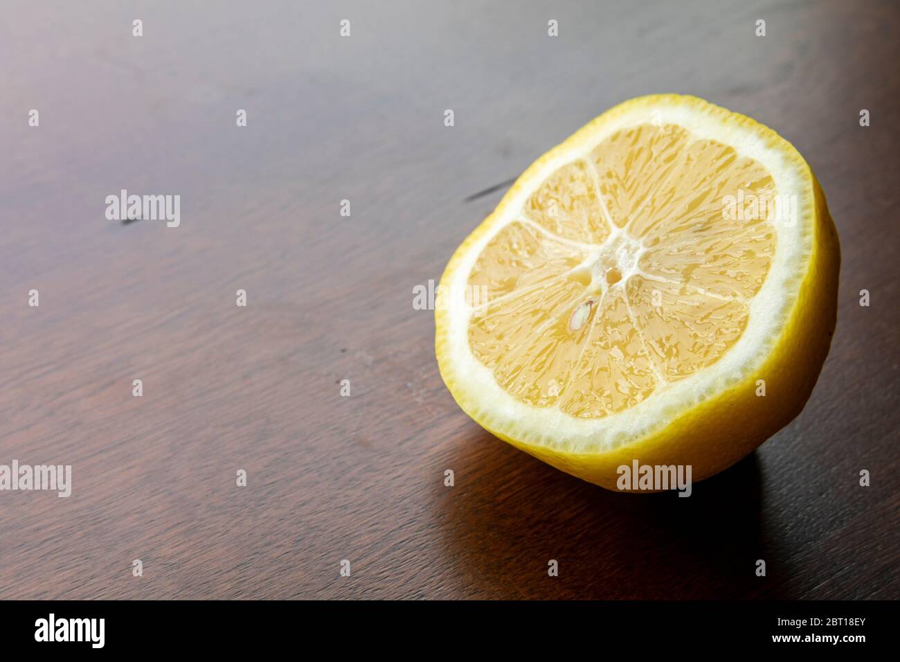 A sliced lemon on a wooden tabletop Stock Photo - Alamy
