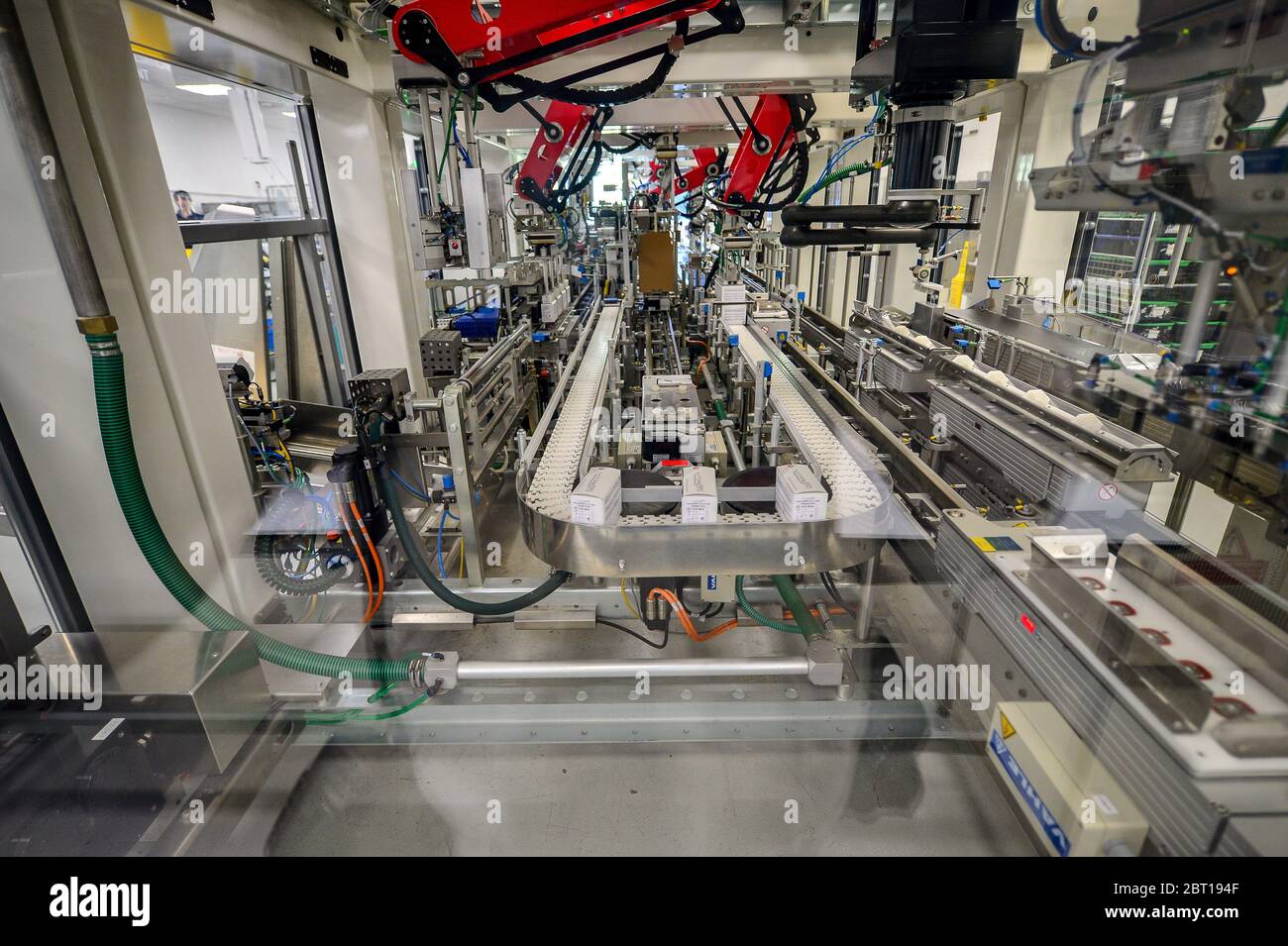 Boxed covid-19 antibody testing kits move along a conveyor behind ...