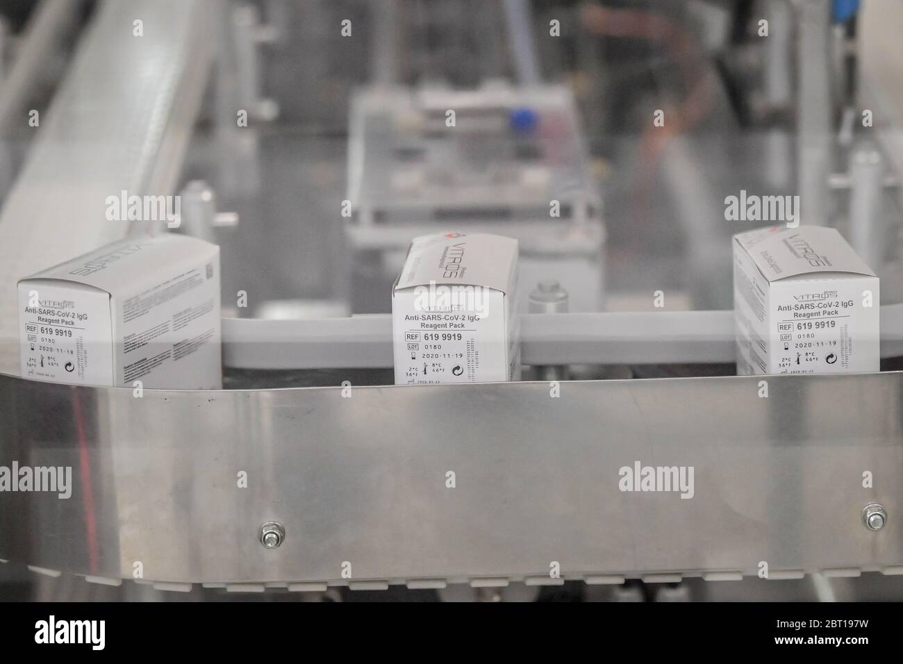 Boxed covid-19 antibody testing kits move along a conveyor behind ...
