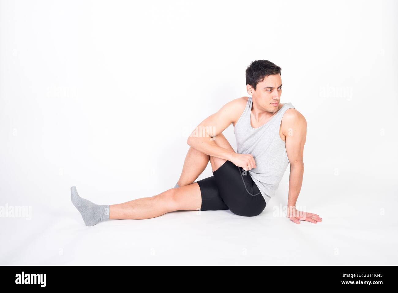 Man in sportswear doing stretching. Full body, white background Stock ...