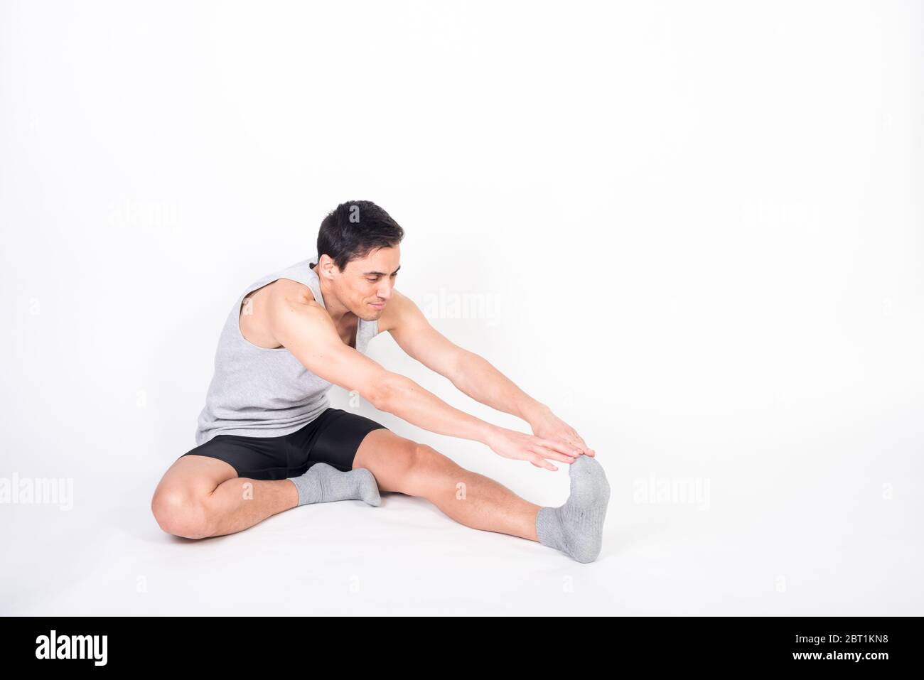 Man in sportswear doing stretching. Full body, white background Stock ...