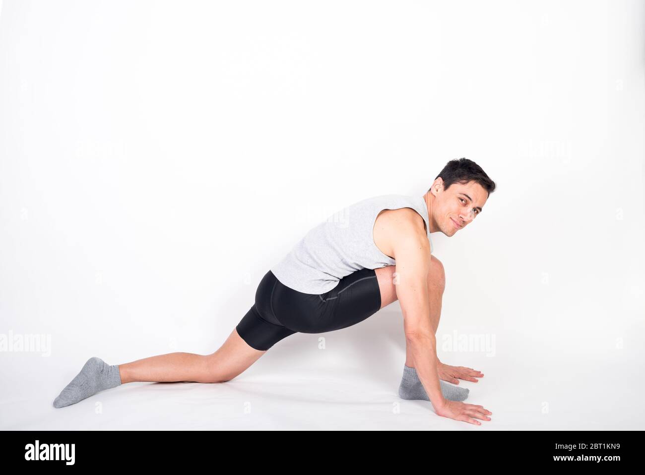 Man in sportswear doing stretching. Full body, white background Stock ...