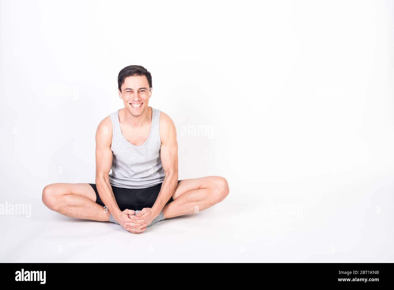 Man in sportswear doing stretching. Full body, white background Stock ...