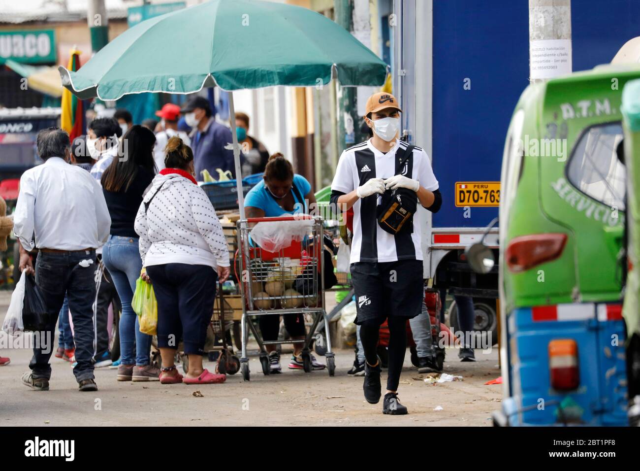 Lima, Peru. 21st May, 2020. People walk near street vendors at a street ...