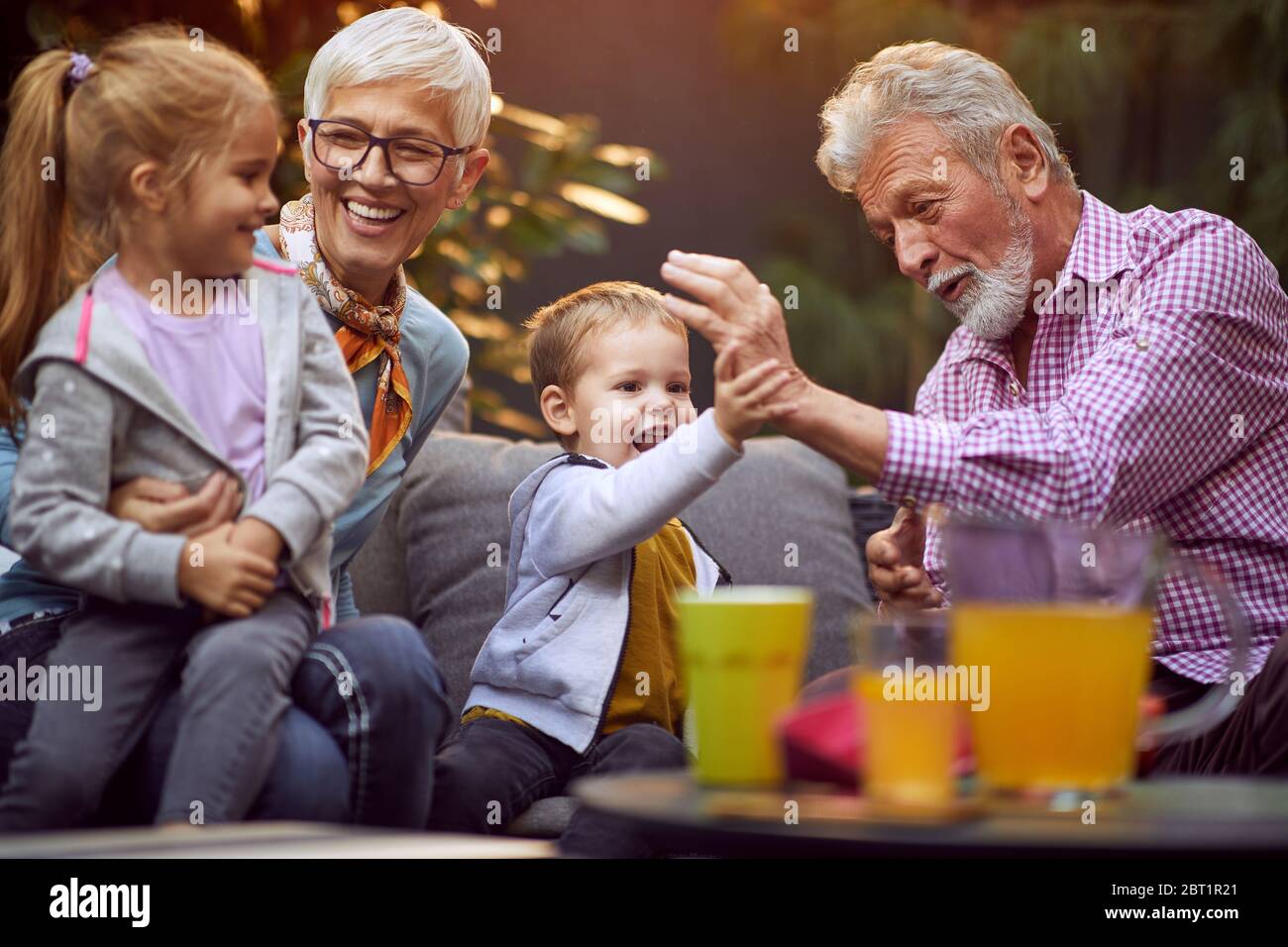 Cheerful grandchildren spending good and funny time with their happy ...