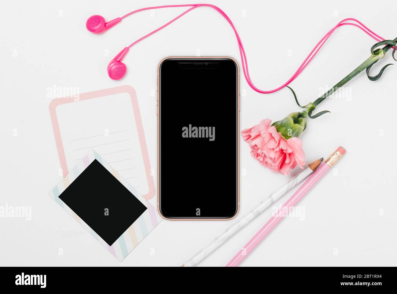 Pink office cellphone layout with desk accessories in a white ...