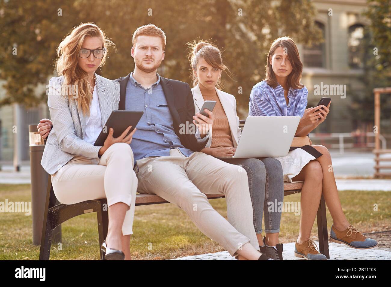 angry caucasian businesspeople sitting outdoor in park at bench ...