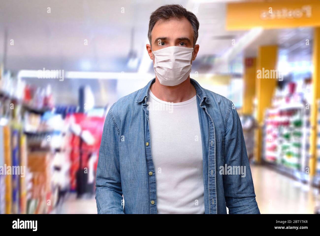 Protected man with face mask walking down a front aisle in a ...
